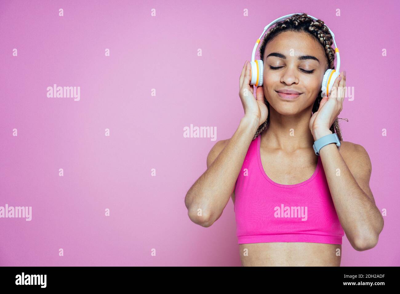 Beautiful girl doing exercises and sport. Posing on a pink colored ...