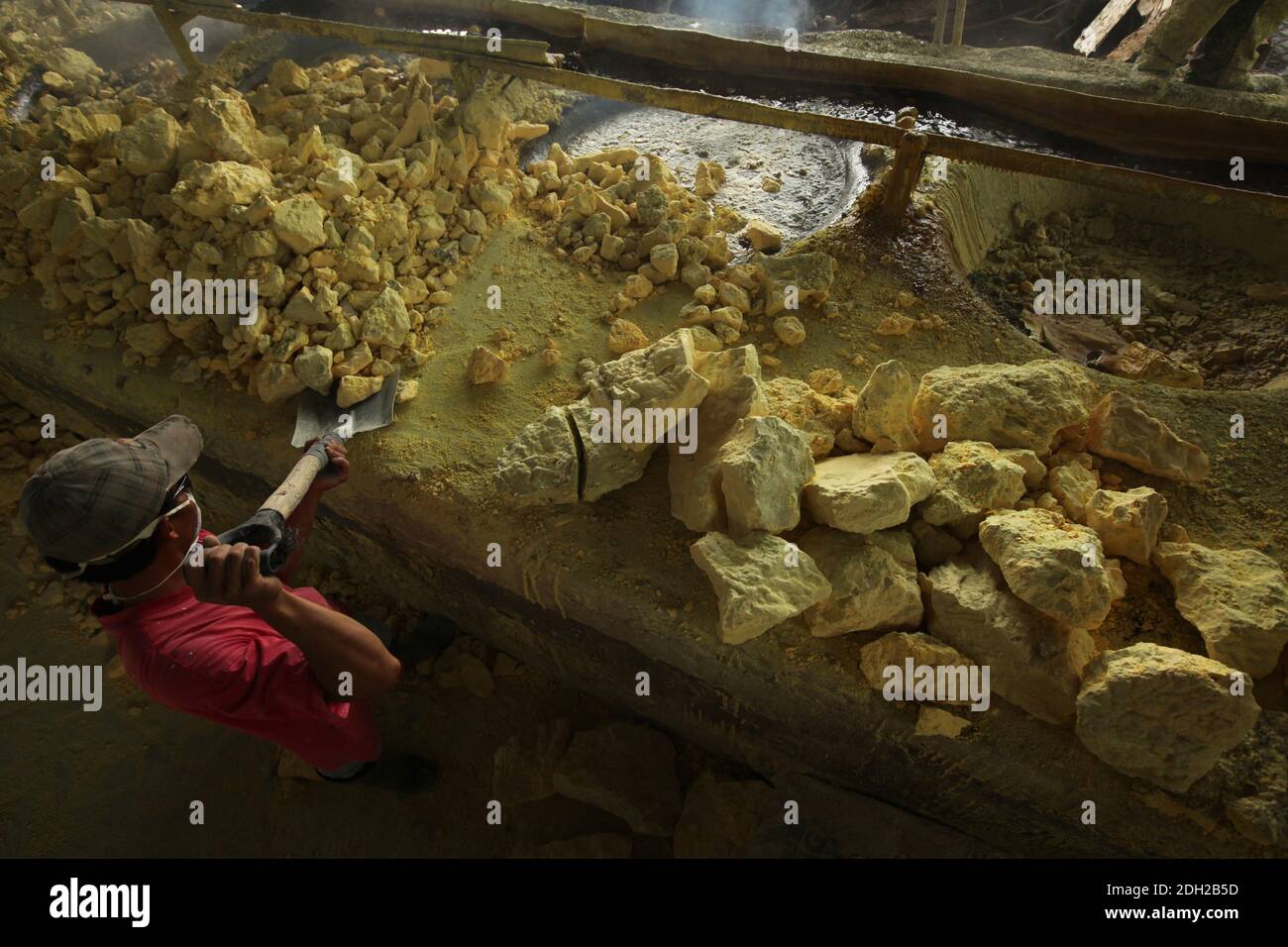 Factory worker loads melting pots with sulphur at the sulphur factory ...