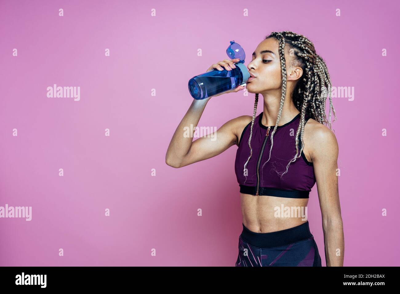Beautiful girl doing exercises and sport. Posing on a pink colored ...