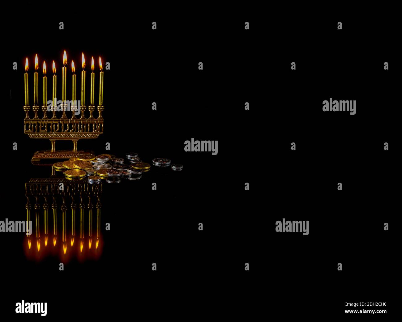 Menorah with golden burning candles, chocolate coins and reflection on ...