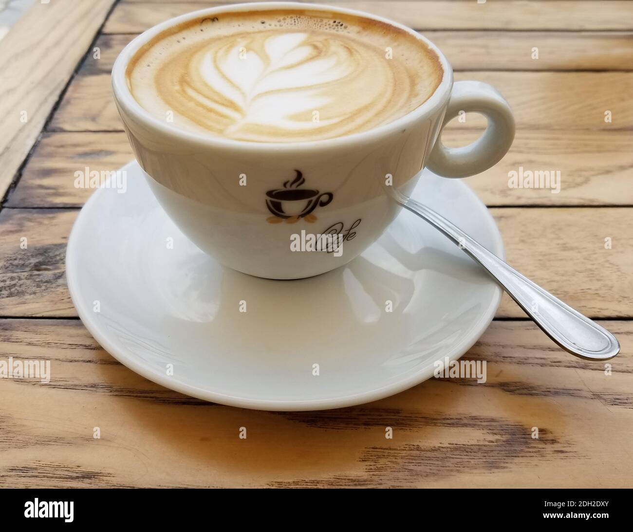 Close-up on a delicious cappuccino coffee cup with cream froth design ...