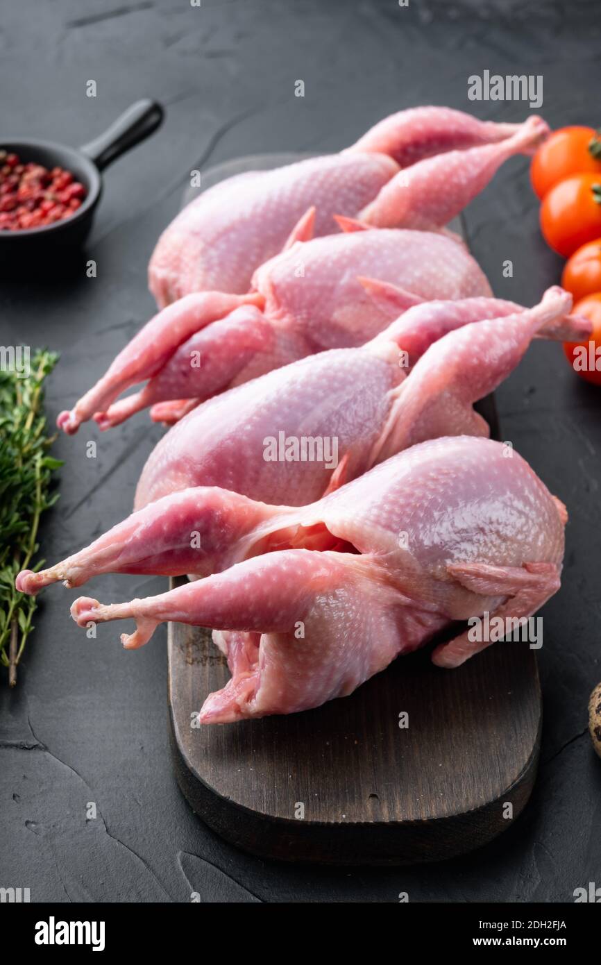 Fresh raw meat quails with herb, on black textured background Stock ...