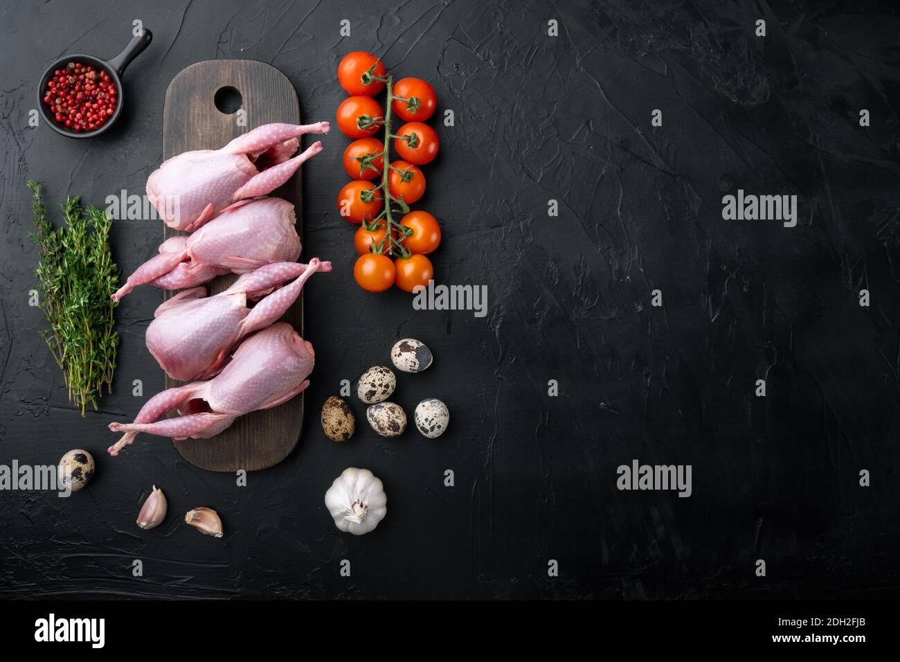 Whole quails meat with spices, herbs, vegetables, top view, on black ...