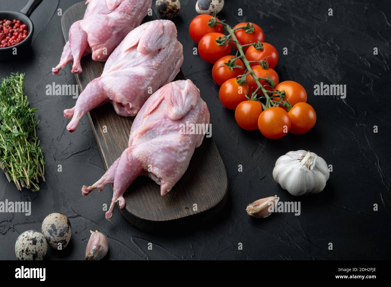 Fresh raw meat quails with herb, on black textured background Stock ...