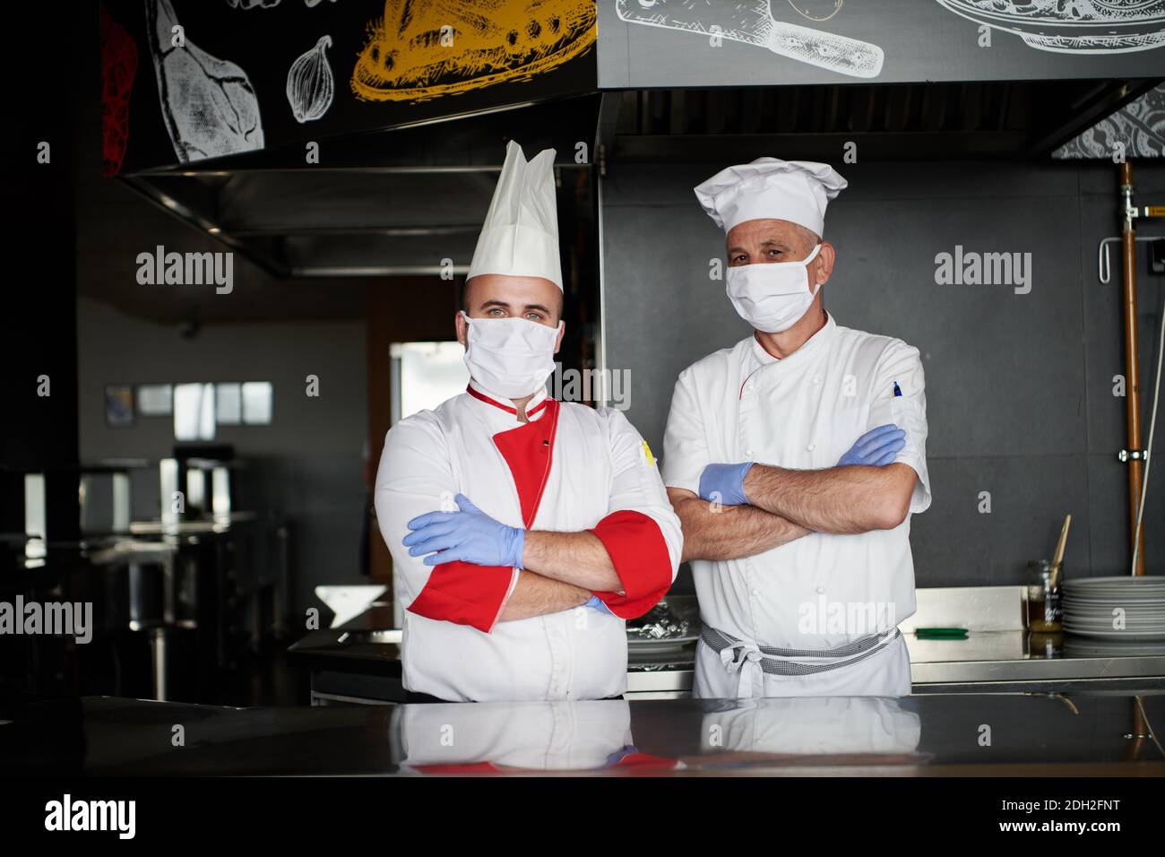 Group chefs standing together in the kitchen at restaurant wearing ...
