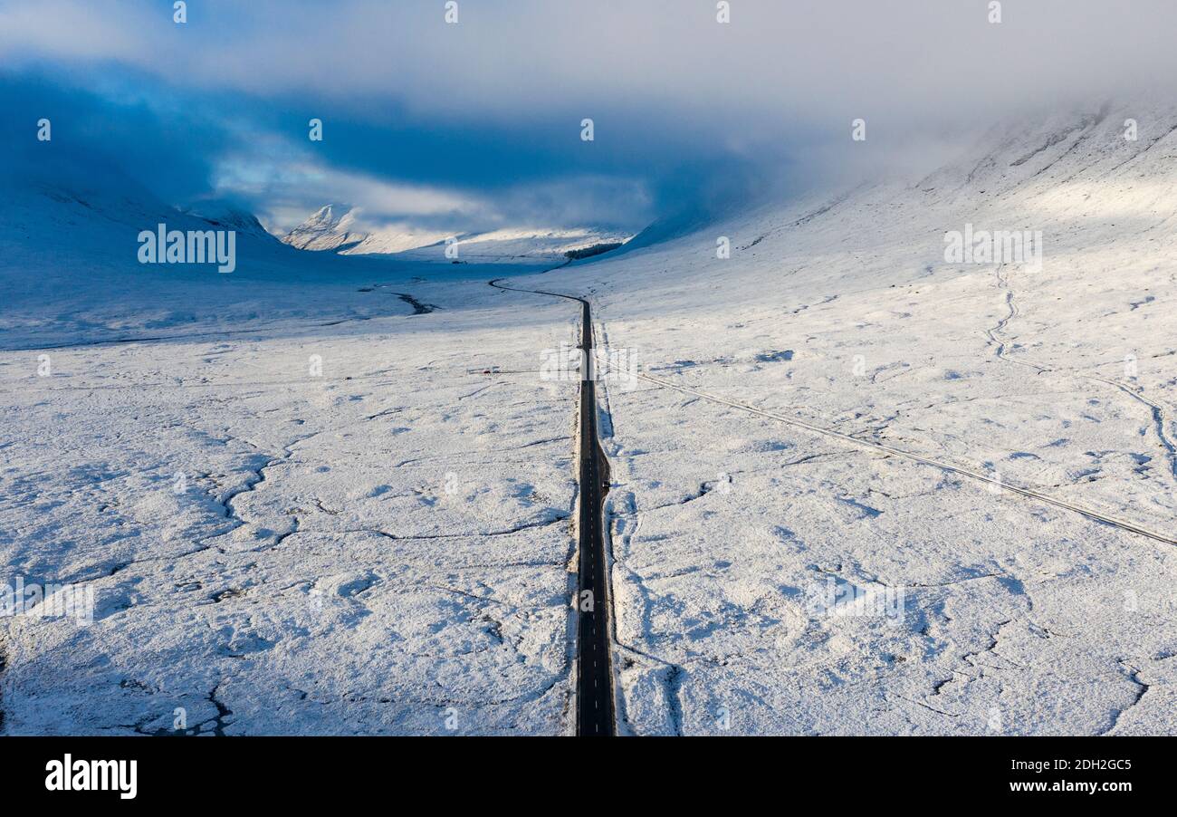 Aerial view of A82 road crossing Rannoch Moor covered in snow during ...