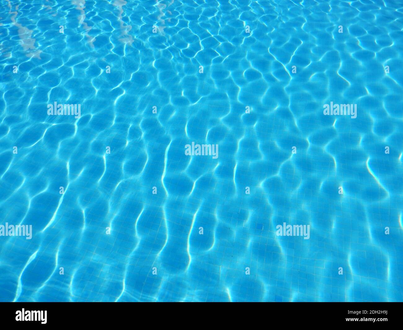 Swimming pool water with ripples and refractions on blue tiles Stock ...