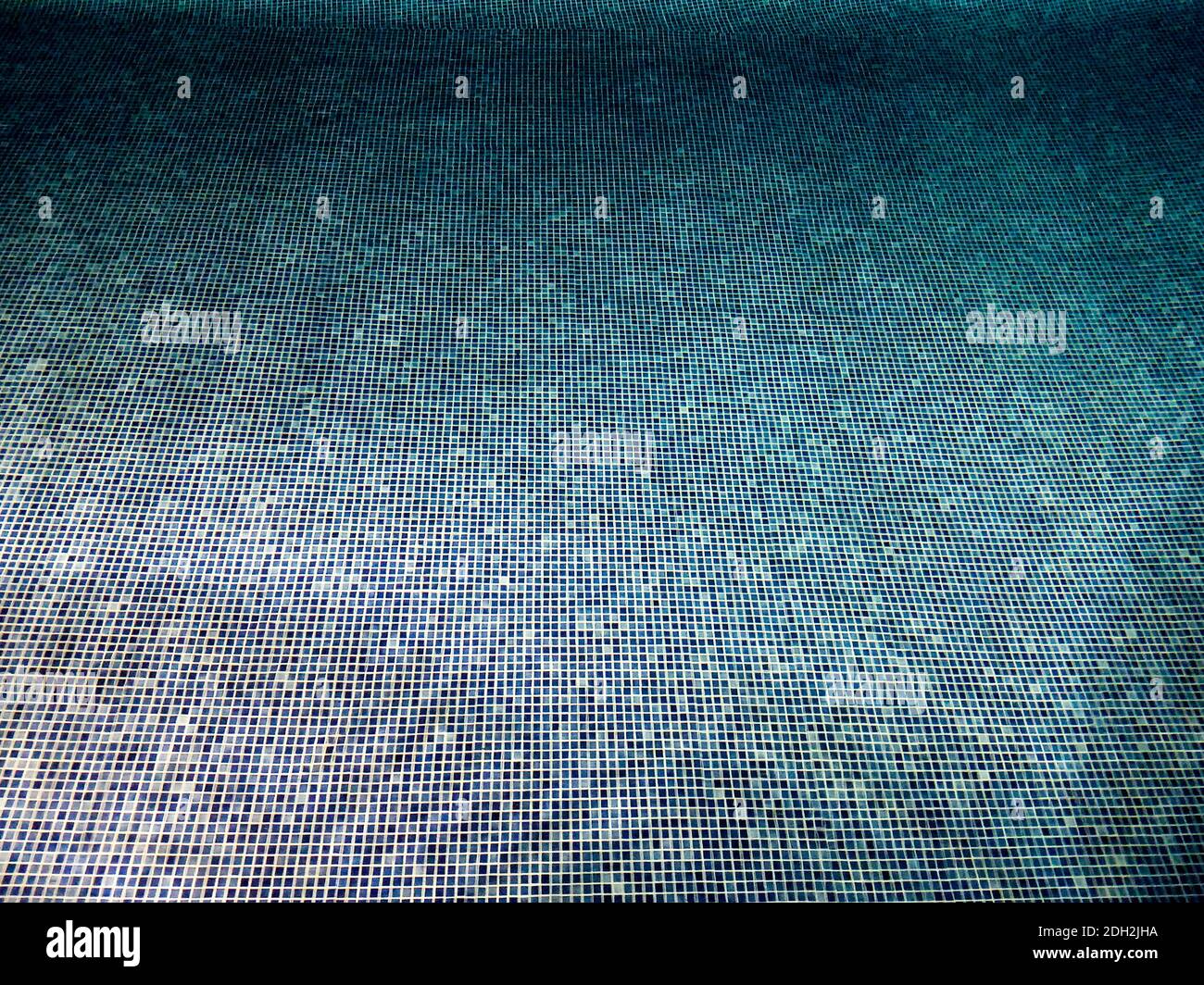 Swimming pool water with ripples and night light refractions on tiles ...