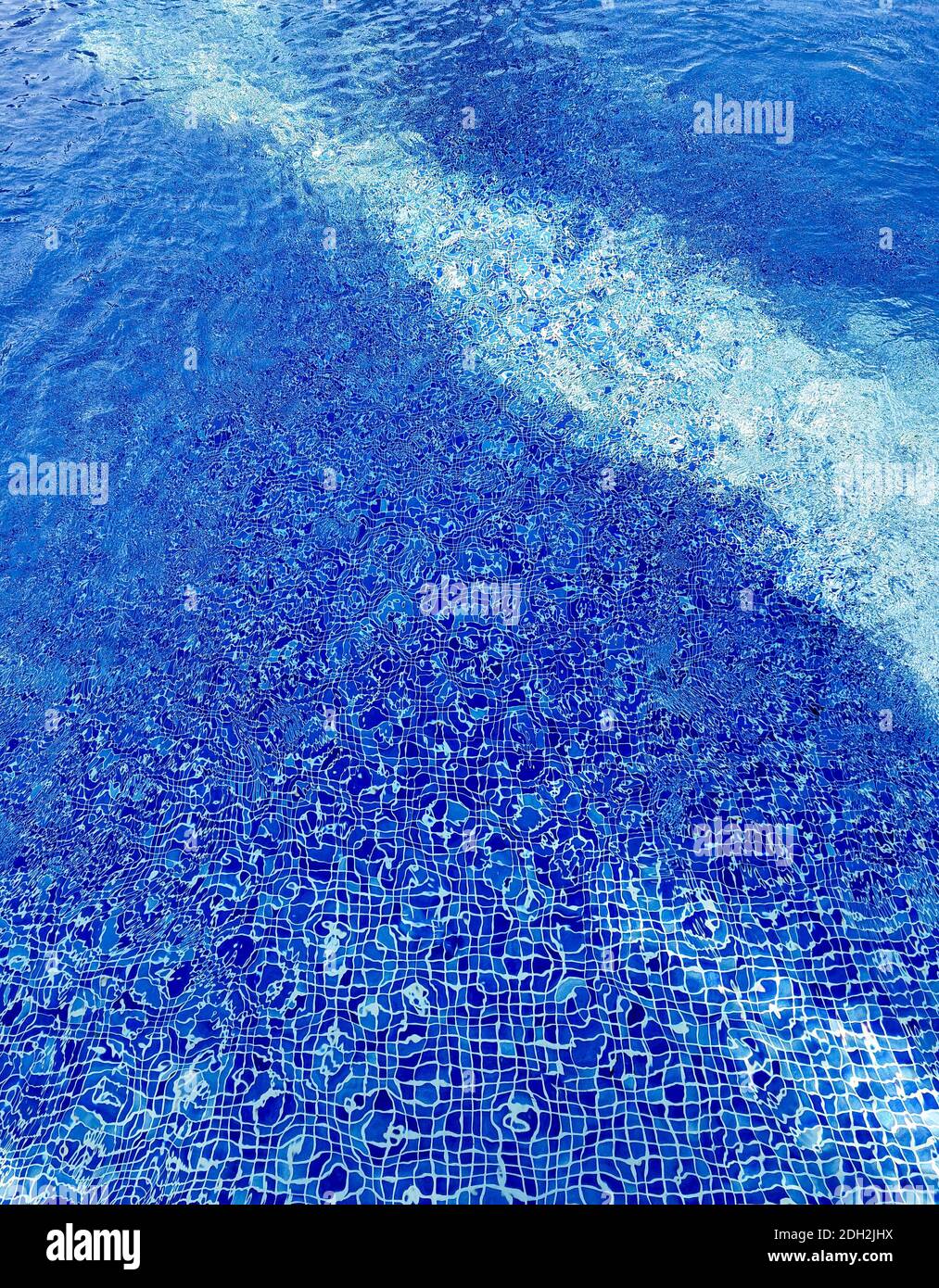 Swimming pool water with ripples and refractions on blue tiles Stock ...