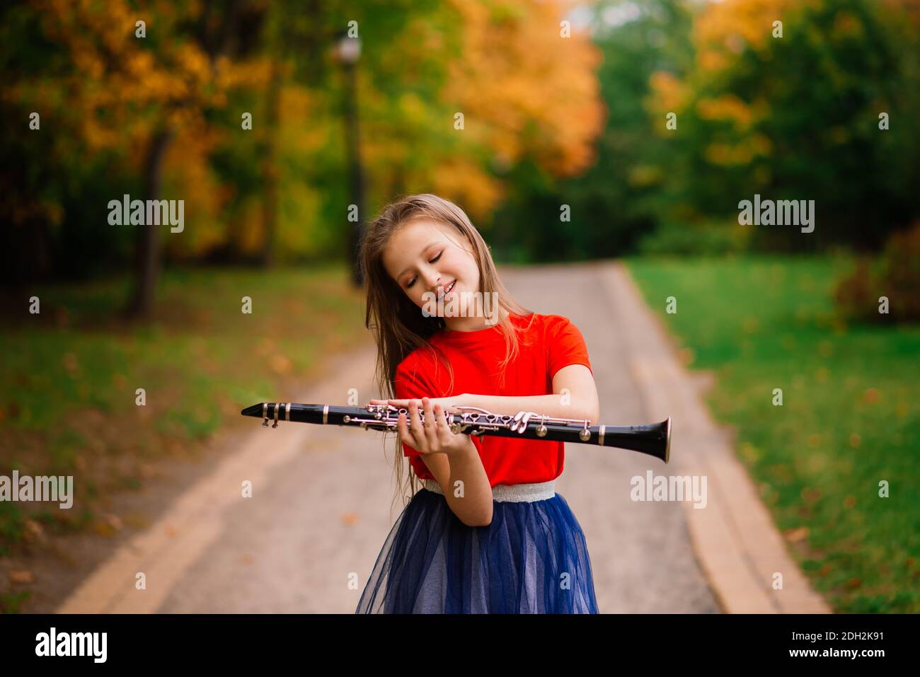 Young attractive girl playing clarinet in fall park Stock Photo - Alamy