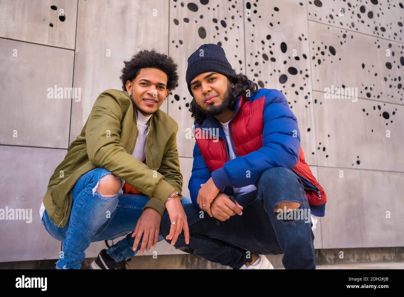 A shallow focus shot of young Latin friends posing at camera and having ...