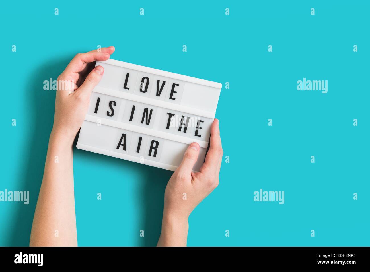 Festive background with woman hands holding glowing lightbox with text ...