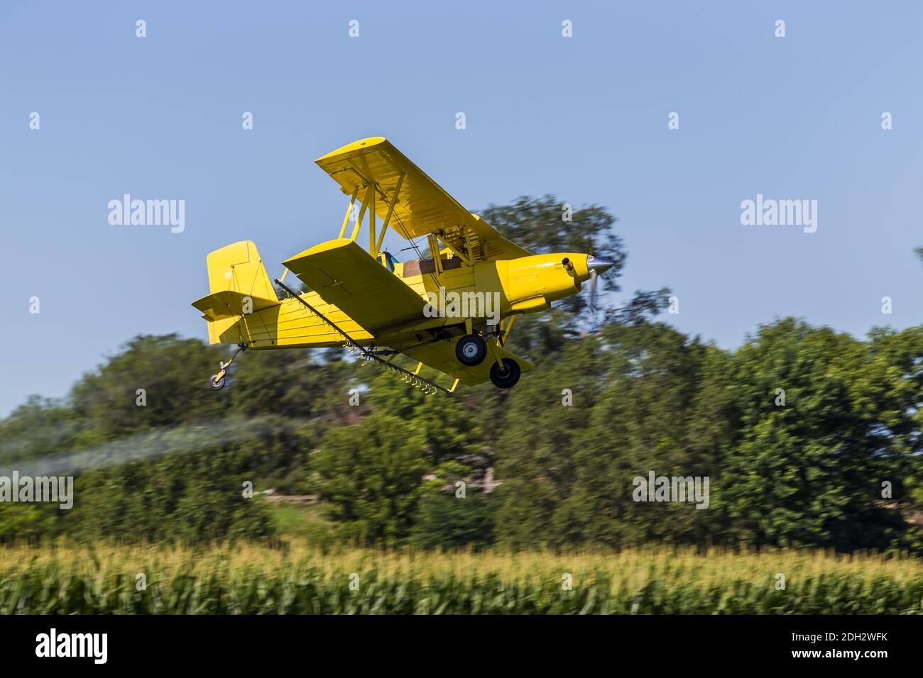 Yellow Crop Duster Spraying Pestisides On Crops Stock Photo - Alamy