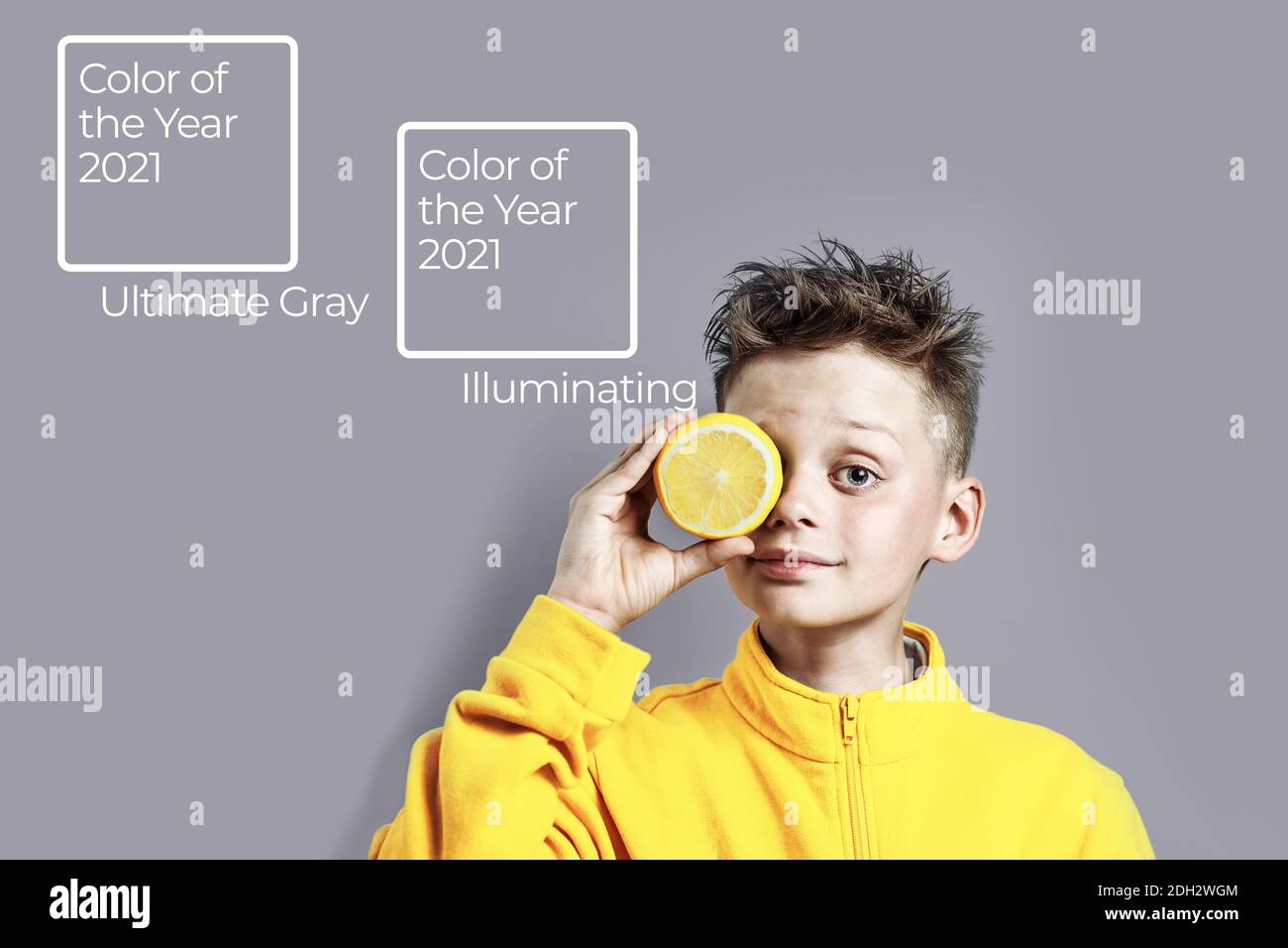 a boy in a bright yellow jacket with a lemon in his hand on a blue ...