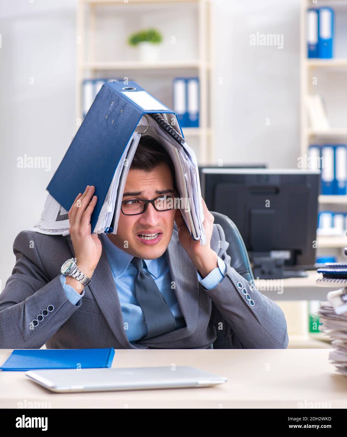 Overloaded with work employee under paperwork burden Stock Photo - Alamy
