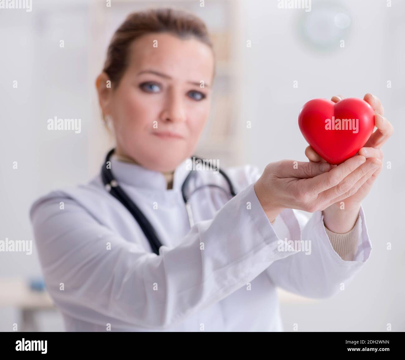 Cardiologist with red heart in medical concept Stock Photo - Alamy