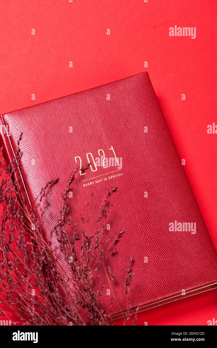 Red diary planner with 2021 year calendar and. Office workspace with ...