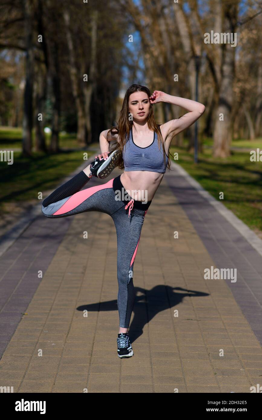A close up of attractive young woman running, doing fitness outdoors ...