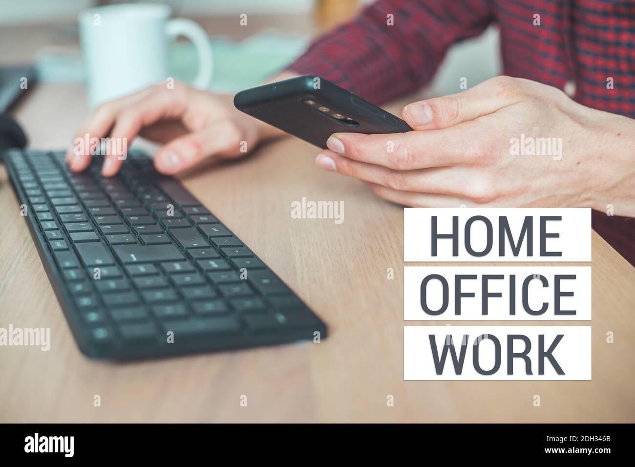 Home office concept: Man is typing on his black mobile phone, Text Home ...