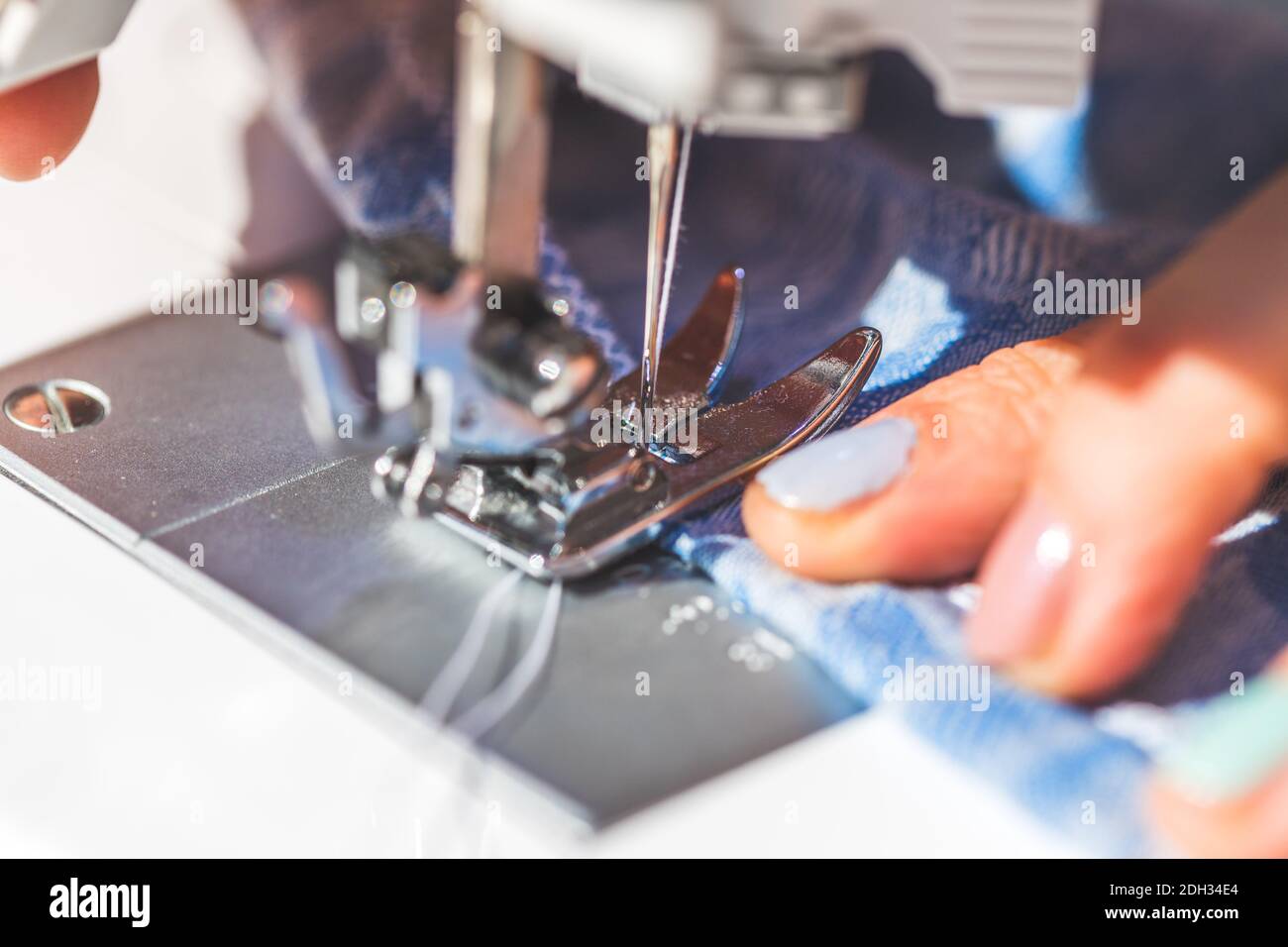 Sewing at home: Woman is sewing at home, close up of sewing needle ...