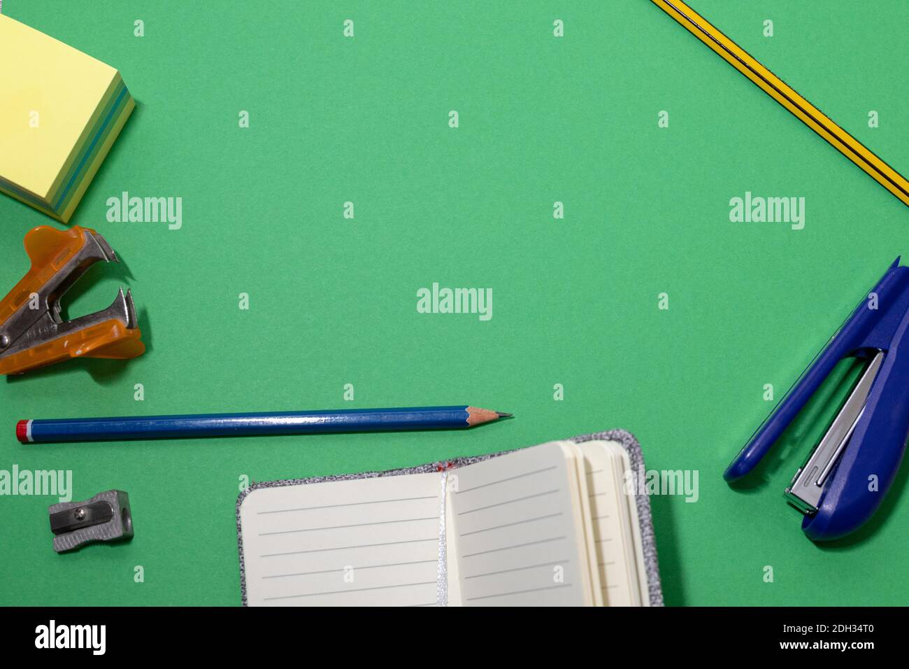 Green background model with stationery objects such as staplers, pens ...