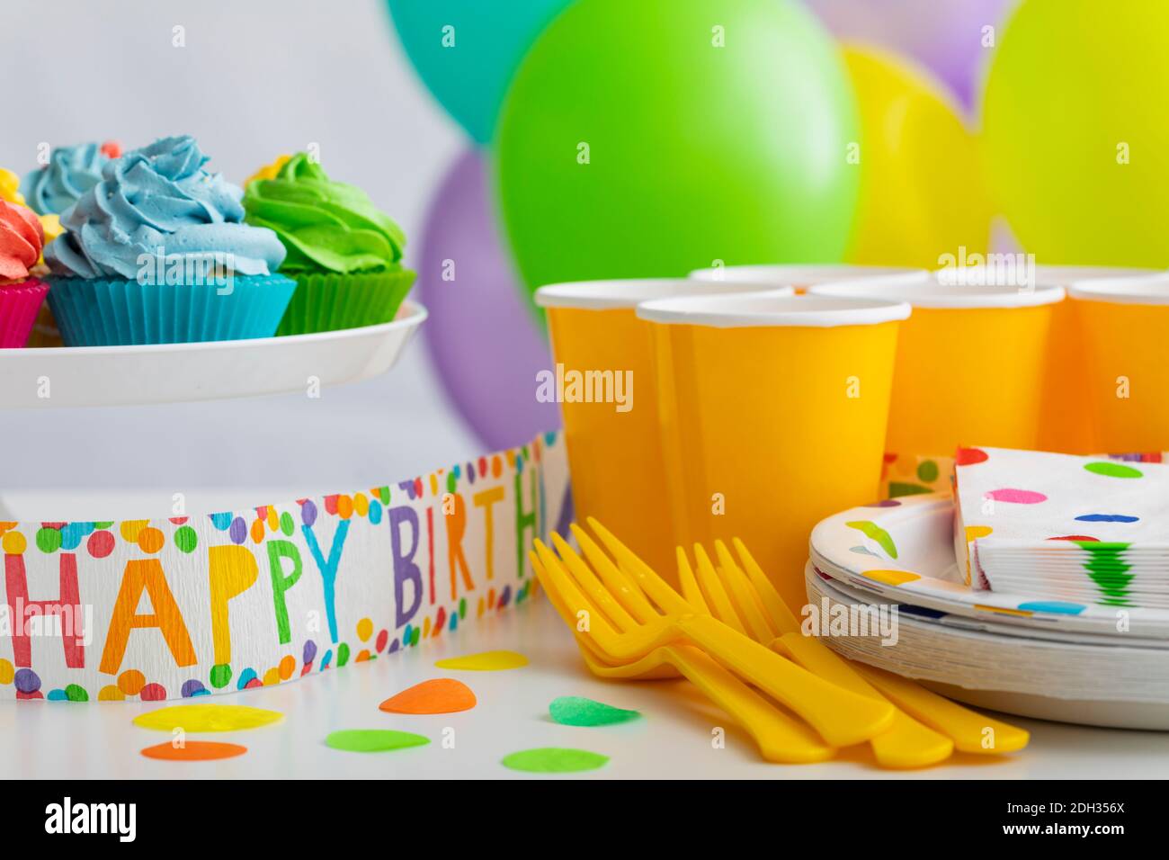 Colorful birthday party setup with cupcakes, yellow cups, and festive ...