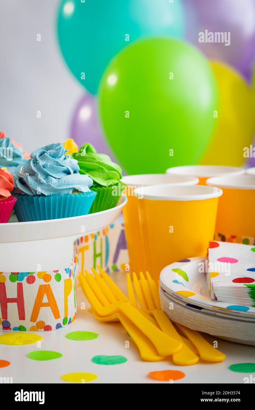 Colorful birthday celebration setup with cupcakes, balloons, and party ...