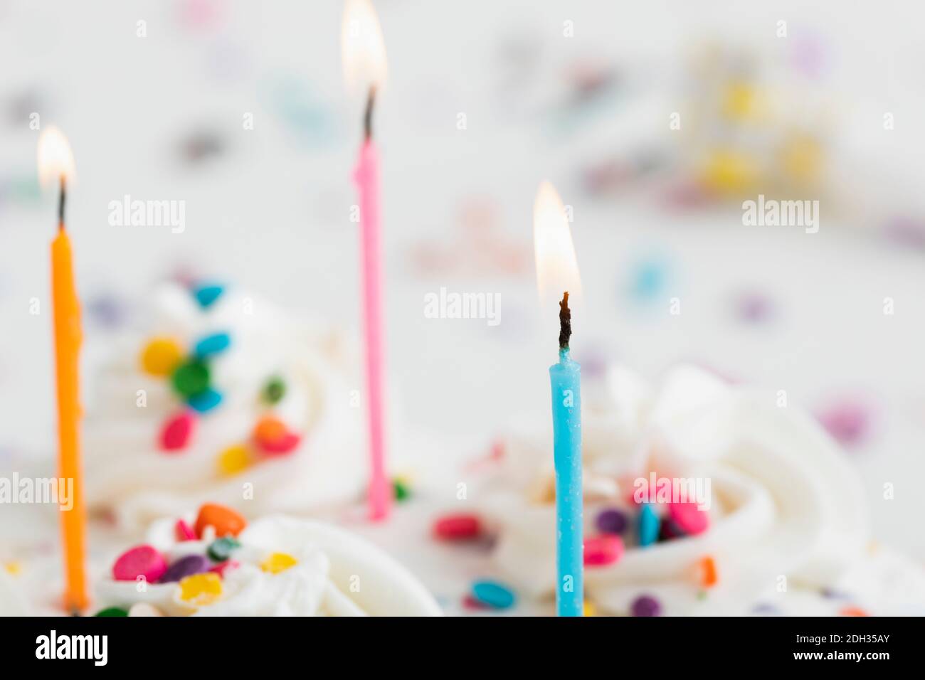 Colorful birthday cake with lit candles and sprinkles ready for ...