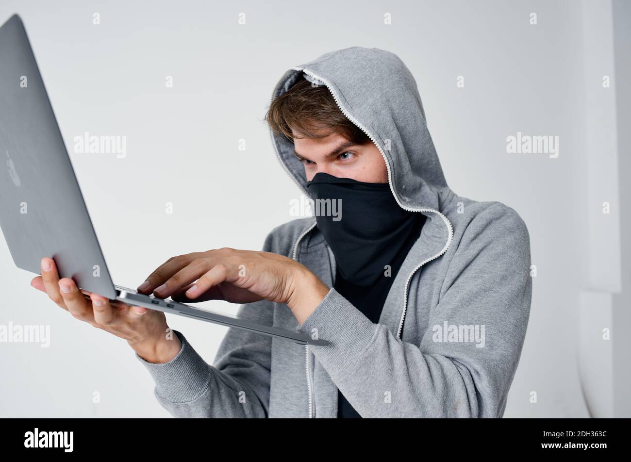 secretive masked man laptop hacker penetration danger Stock Photo - Alamy
