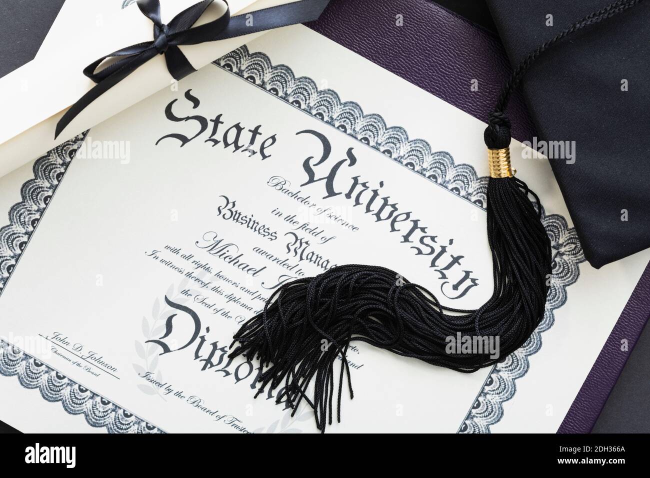 Celebration of achievement with a diploma and graduation cap displayed ...