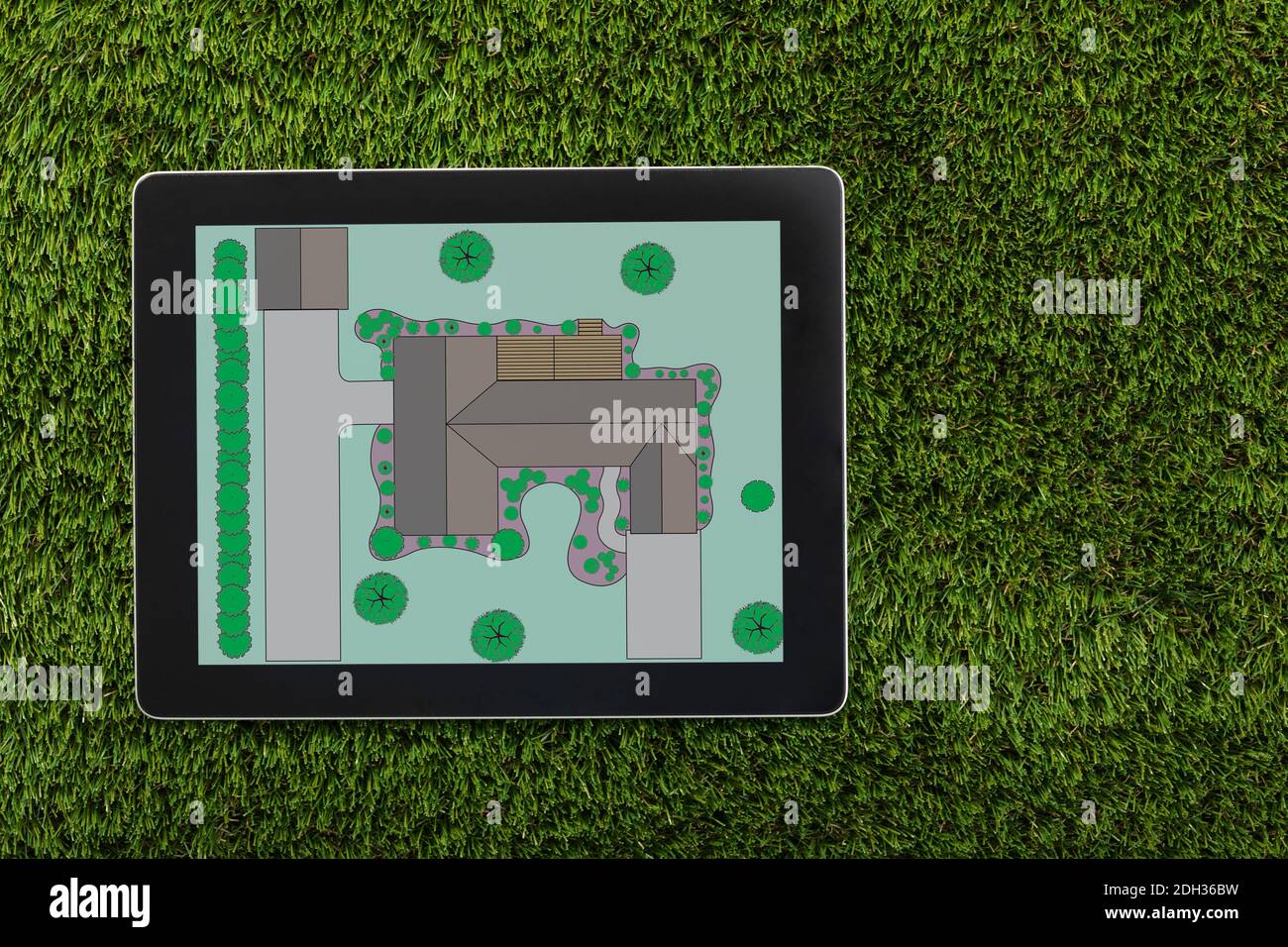 Landscape design plan displayed on tablet on green grass surface in a ...