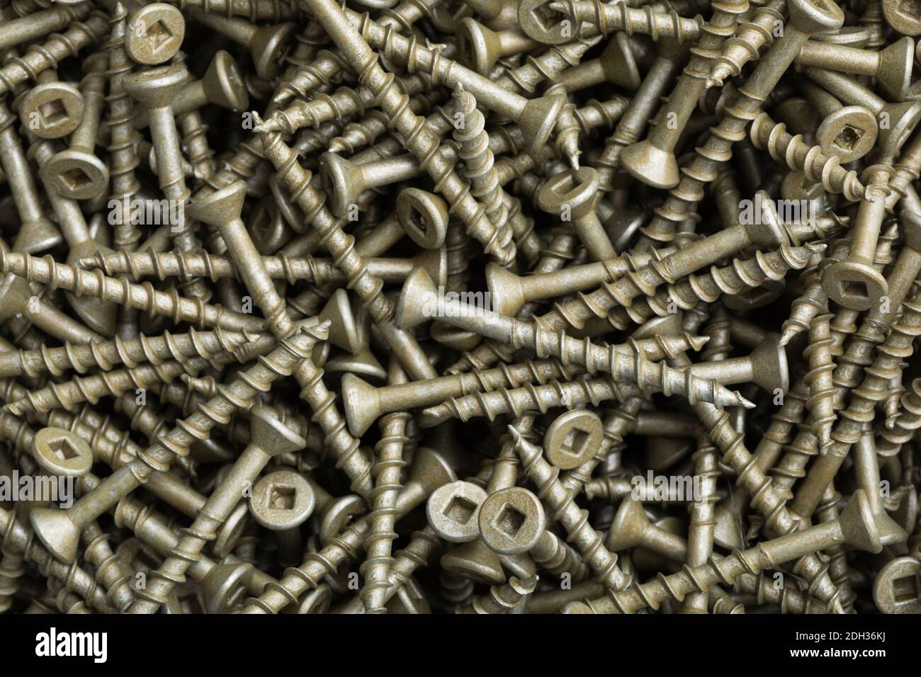 Metal screws scattered across a surface in a workshop environment ...