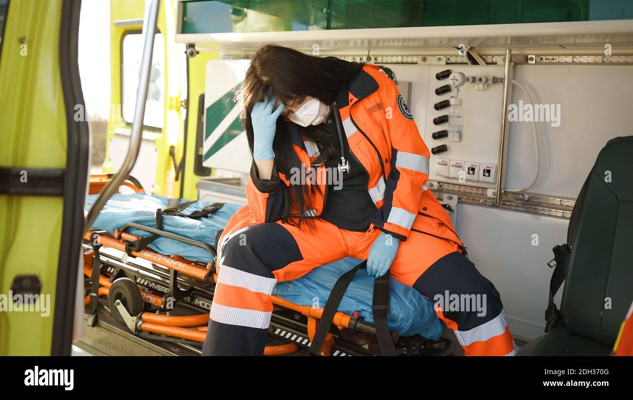 Exhausted female paramedic in face mask makes face palm Stock Photo - Alamy