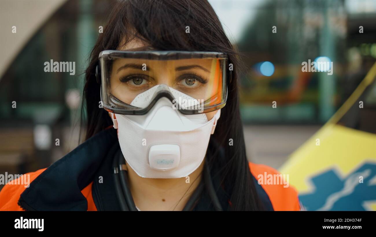 Sad female paramedic stares at you feeling alert standing near ...