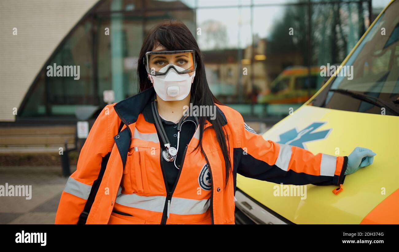 Sad female paramedic stares at you. Writing on clothes means Urgent ...