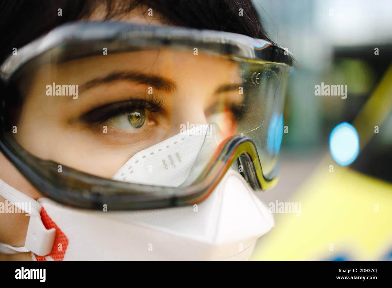 Macro eye view of sad female paramedic feeling alert with blue lights ...