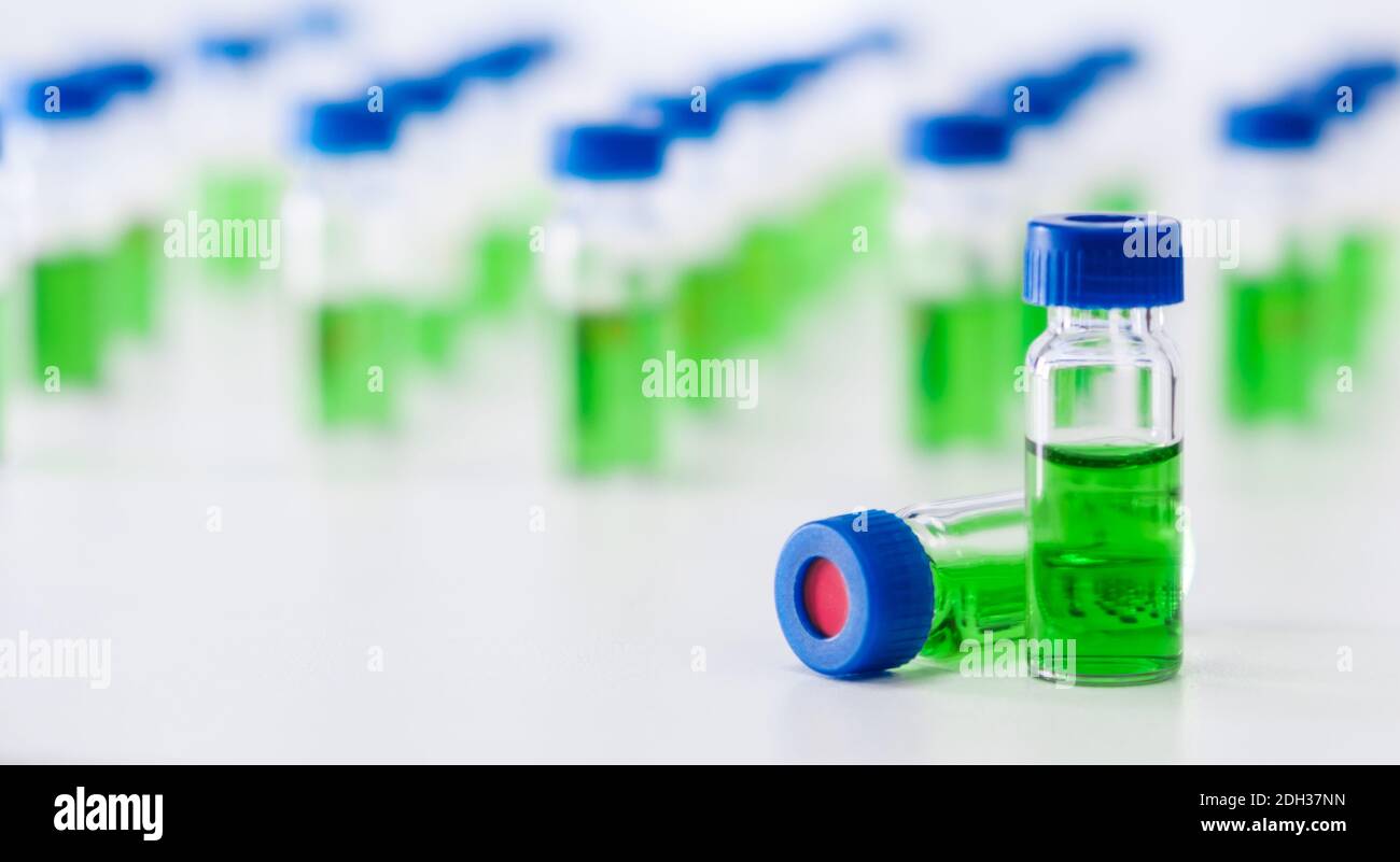 HPLC vials with green sample of plant extracts. Developing of drugs ...