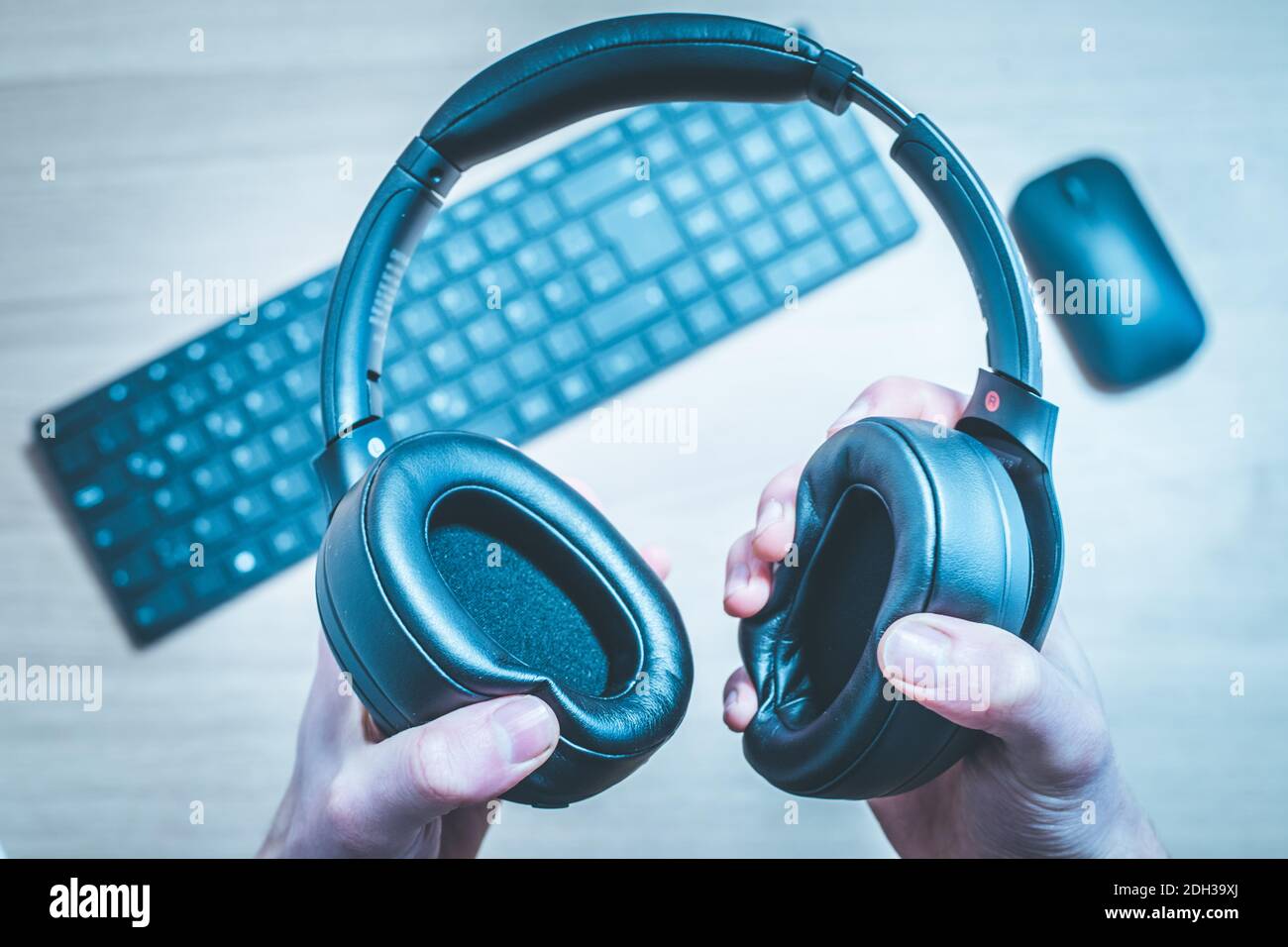 Workspace audio concept: Holding black wireless headphones, workspace ...
