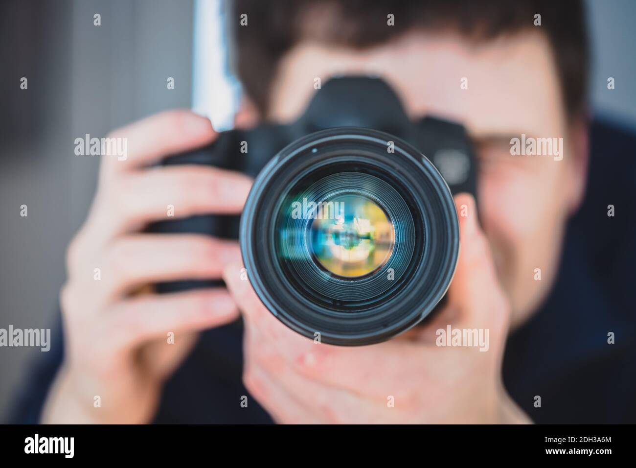 Photographer at work: Man is standing behind a professional camera on a ...
