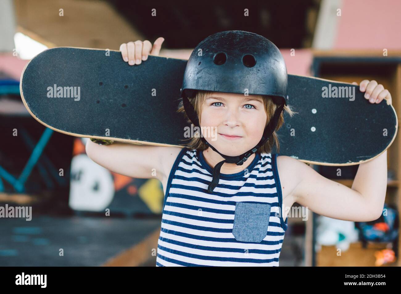 Skateboarder boy in helmet posing in skate park. Kid boy with ...
