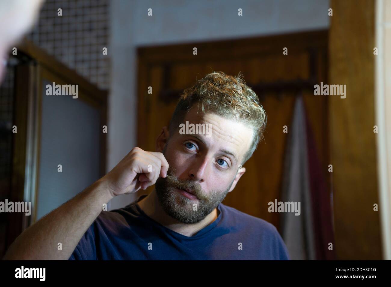 man observing and taking care of himself in front of the bathroom ...
