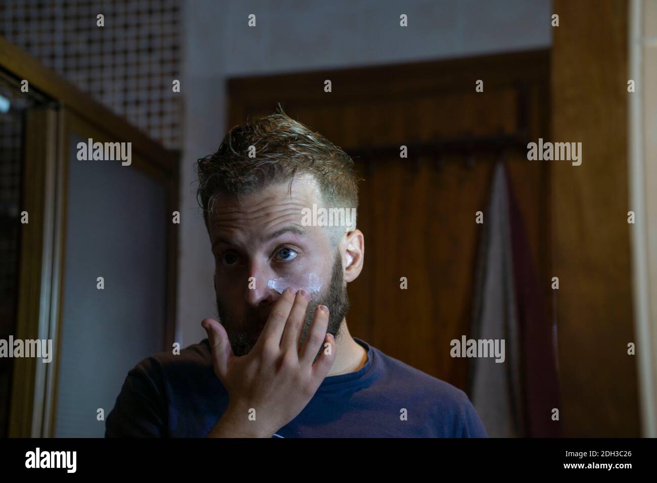 man observing and taking care of himself in front of the bathroom ...