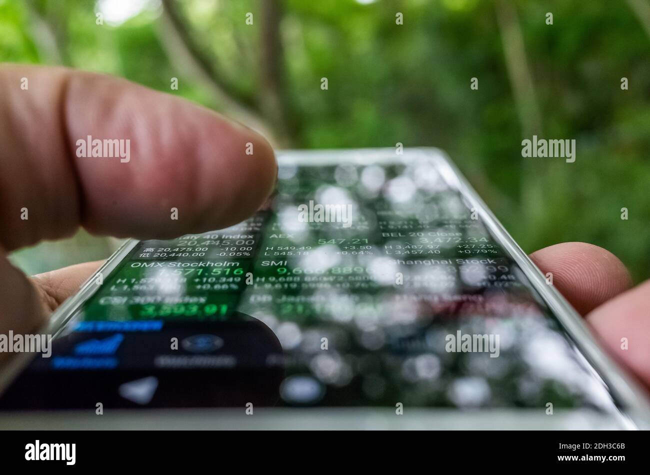 Using a mobile device to check market data Stock Photo - Alamy