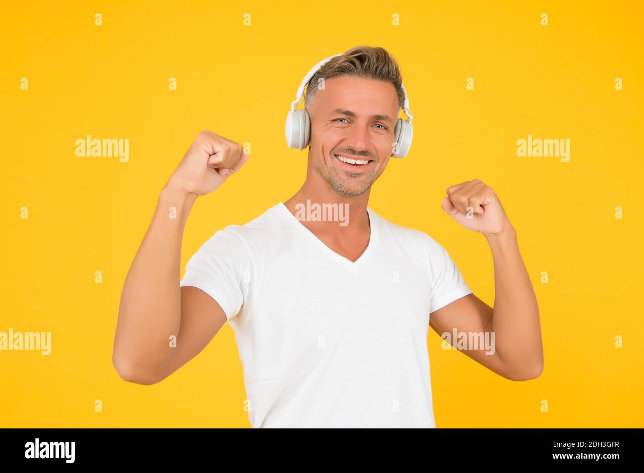 Music is power. Happy man flex arms yellow background. Audio power ...
