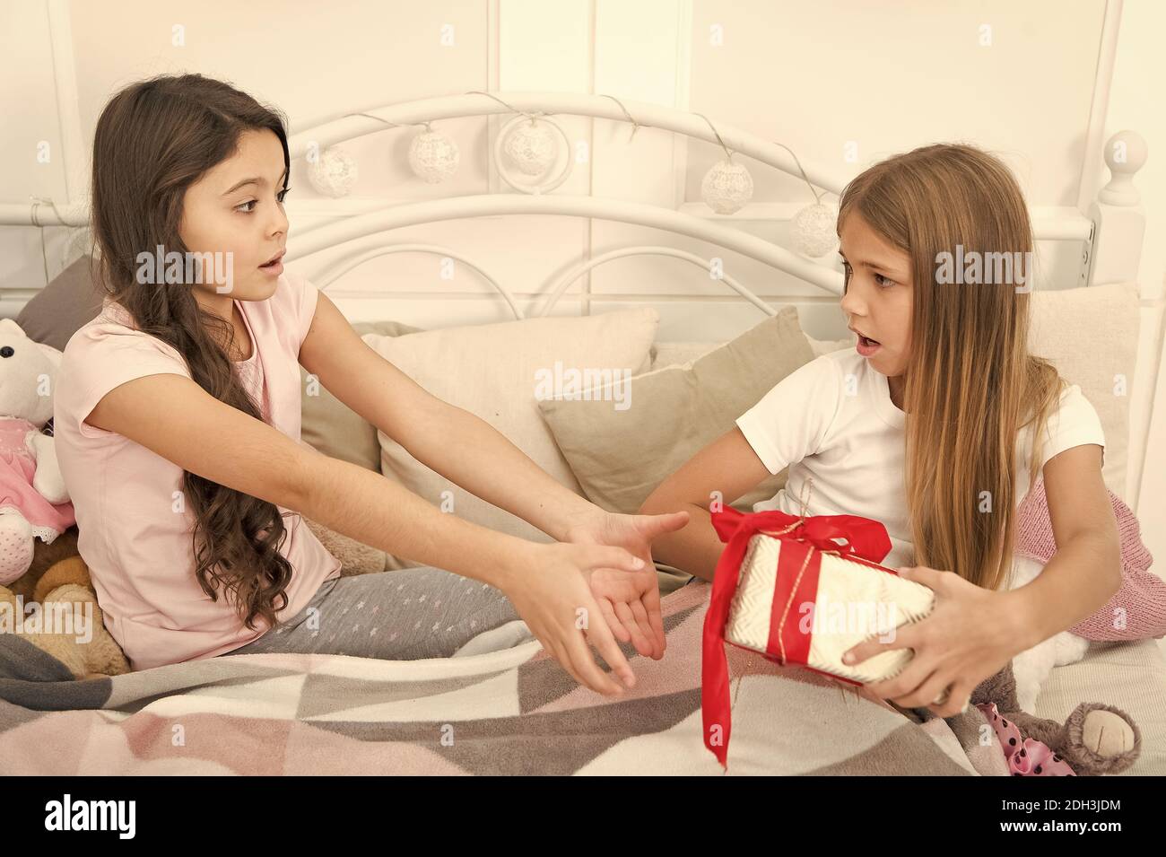 The present is mine. Little girls fight over present box. Giving ...