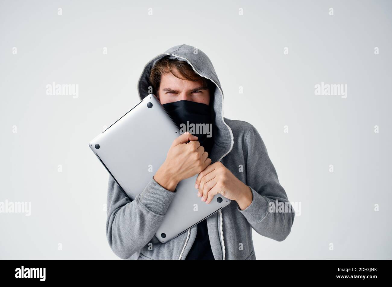 secretive masked man laptop hacker penetration danger Stock Photo - Alamy