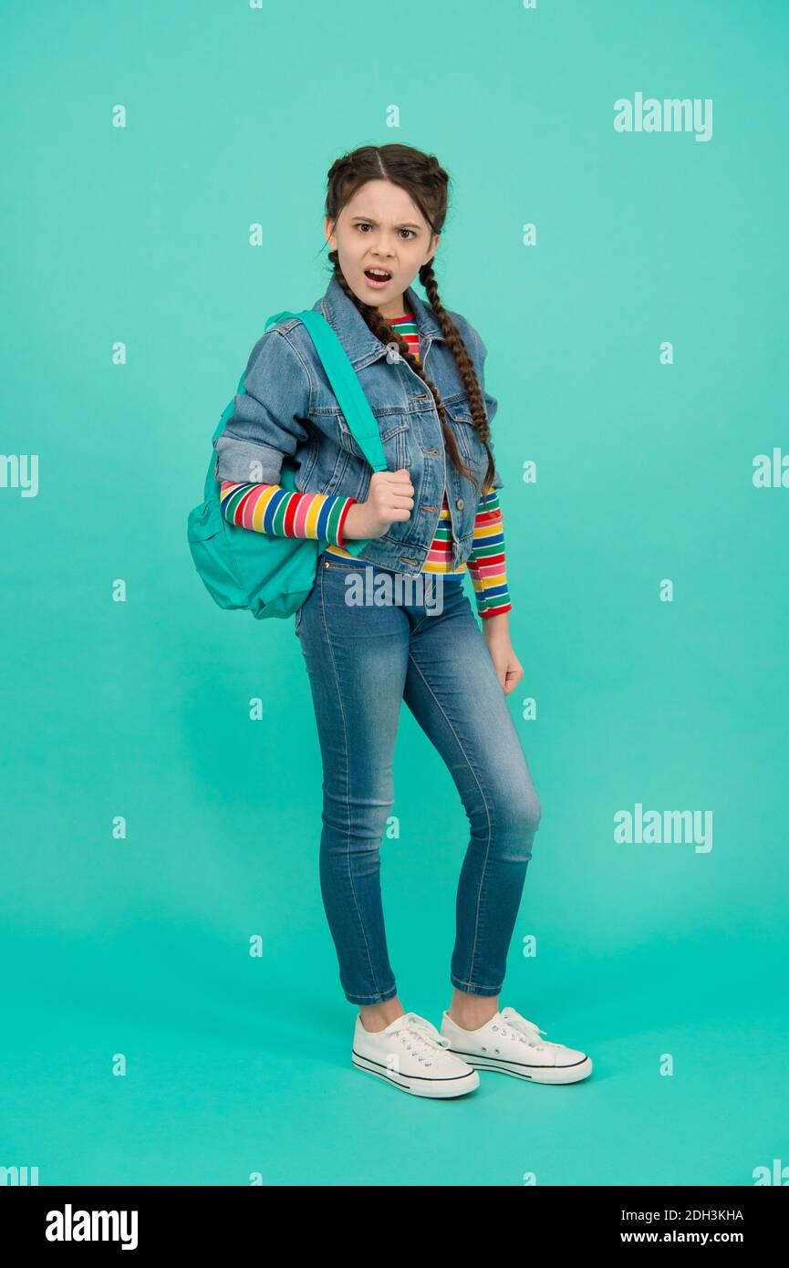 Unhappy kid with irritated look in casual fashion style carry backpack ...