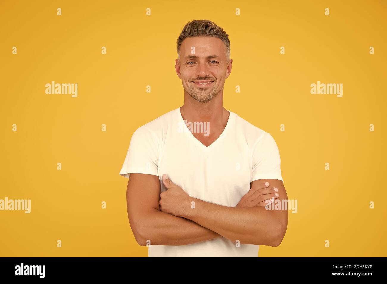 Confident and optimistic. Confident man with crossed arms yellow ...