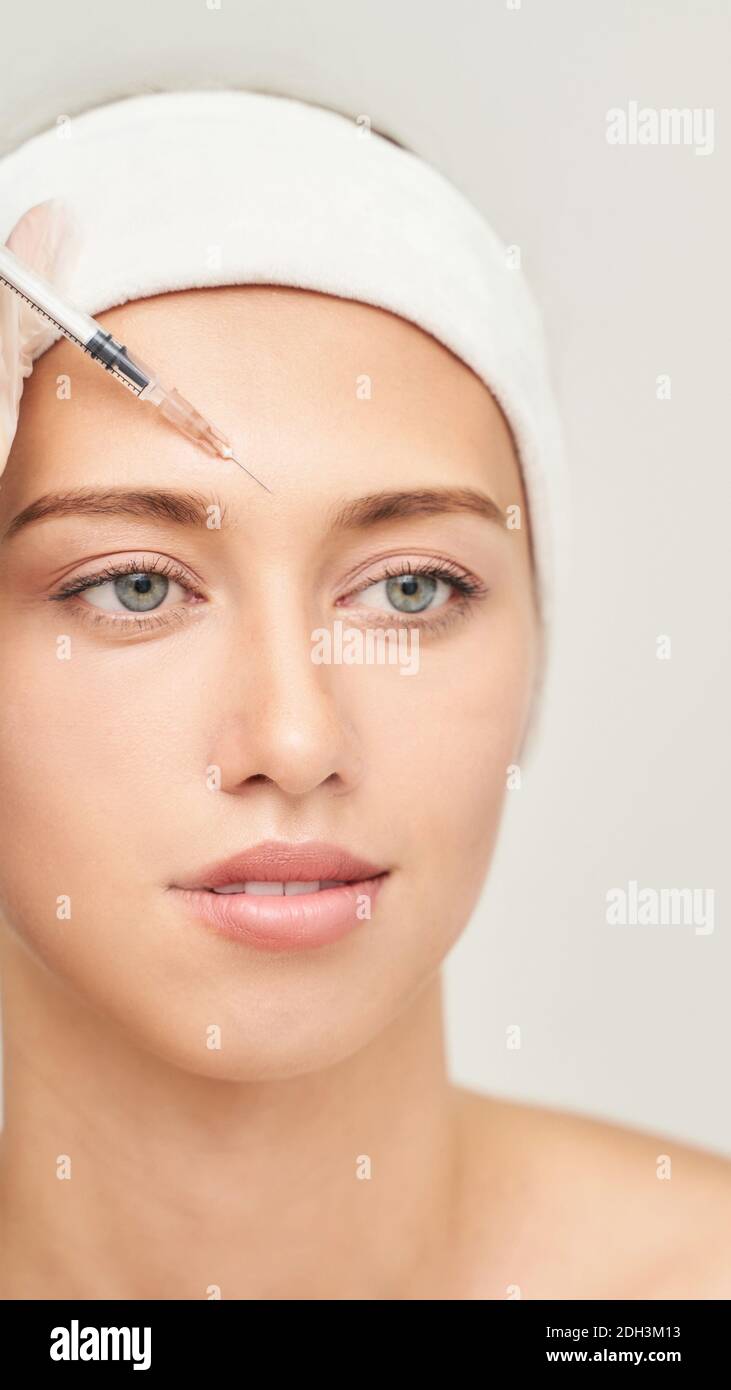 Forehead injection at spa salon. Doctor hands. Pretty female patient ...