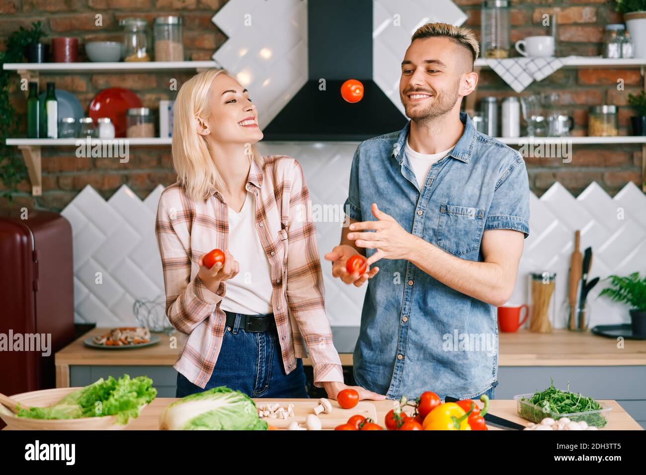 Happy smiling couple having fun cooking together in kitchen Stock Photo ...